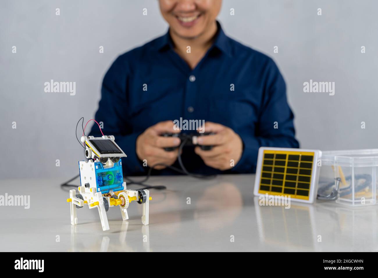 Child's hands working with circuits, wires, computer chip, OLED, motor, wheels on his robotics ...