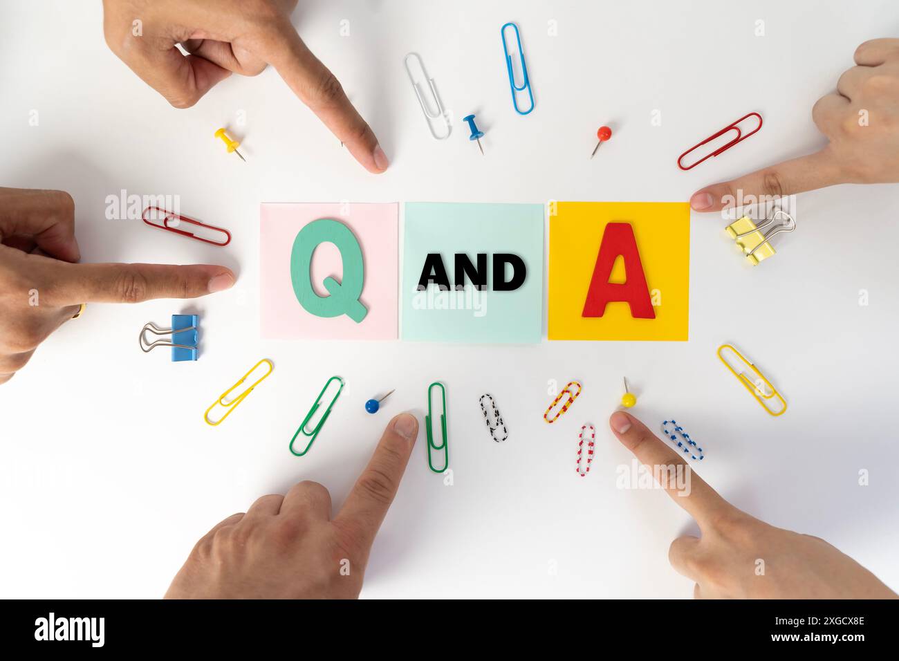 Conceptual text "Q and A" on colorful wooden letters. Index finger ...