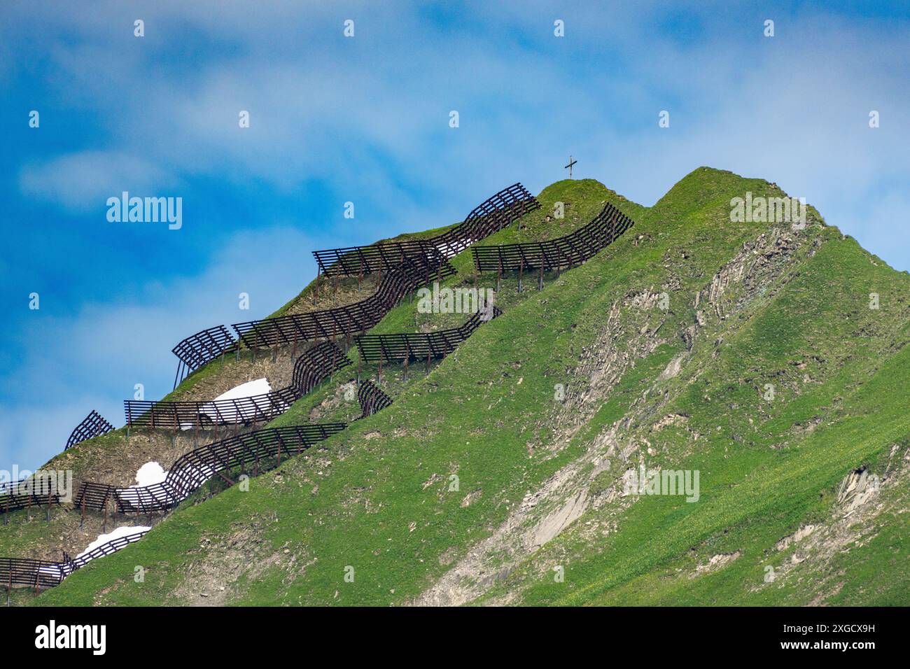 Avalanche barriers on the steep mountain slope above a village in the ...