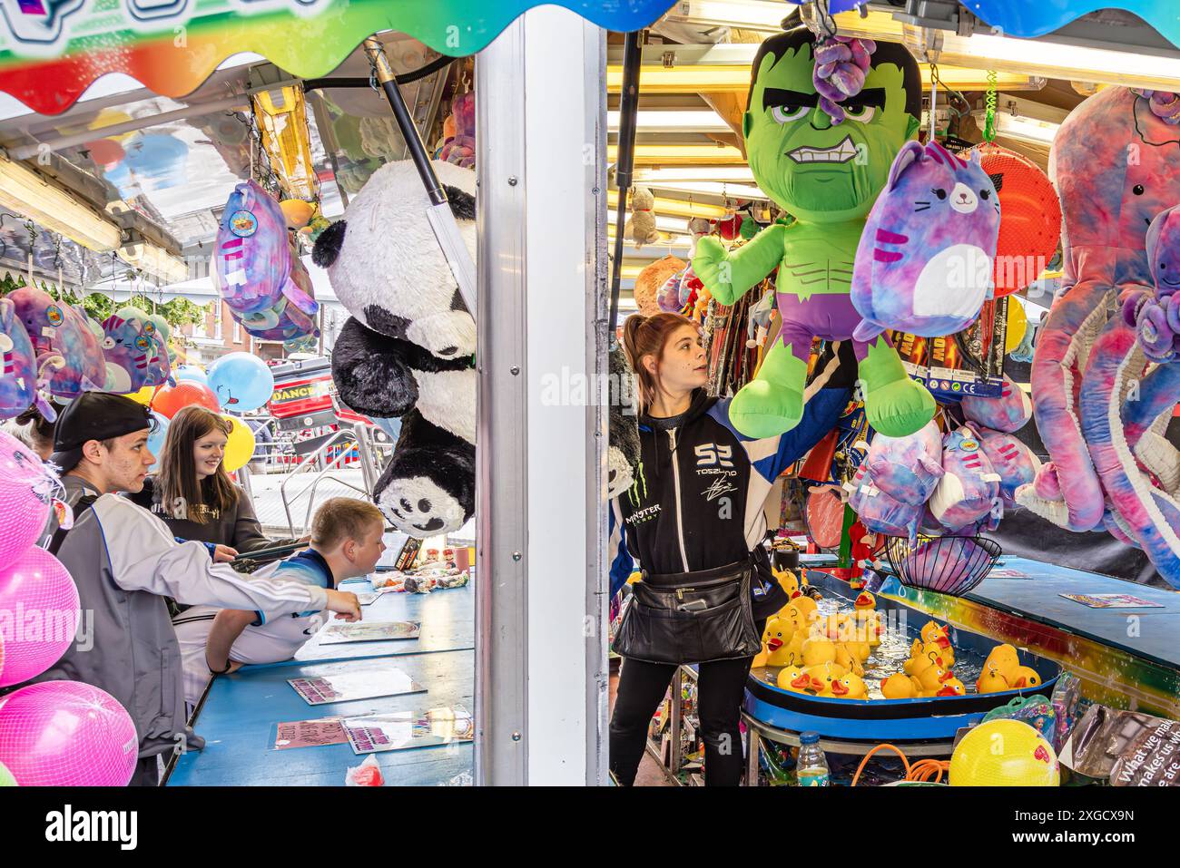 Children trying to win a prize at a fairground game. Fairground booth ...