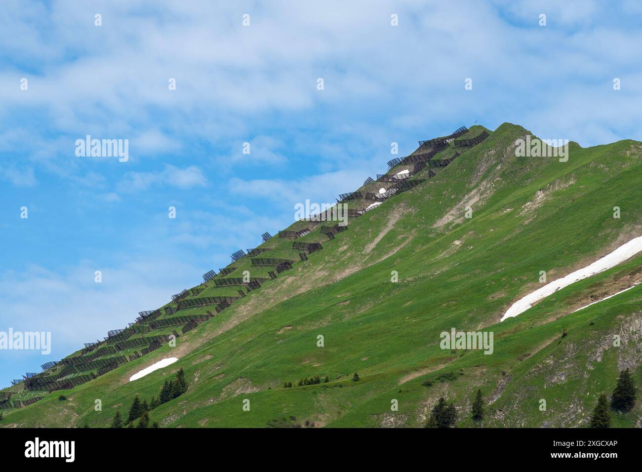 Avalanche barriers on the steep mountain slope above a village in the ...