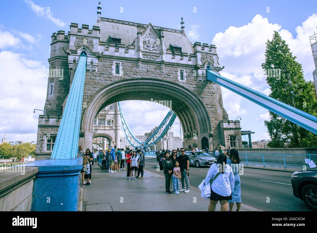 People walk on Tower Bridge in London as many tourists are expected to ...