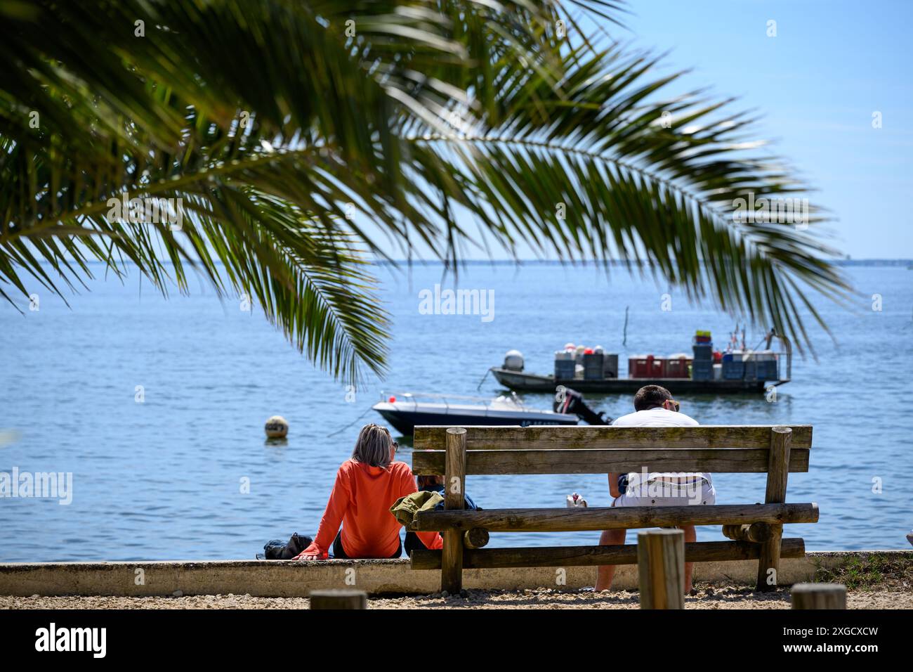 Cap Ferret, France - June 13 2024: Tourists sitting on a public bench ...