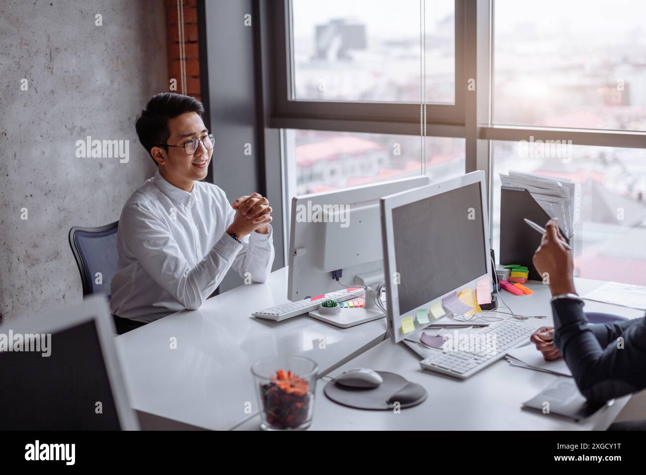 Portrait of Asian male lowyer in formal white shirt sitting at his desk ...