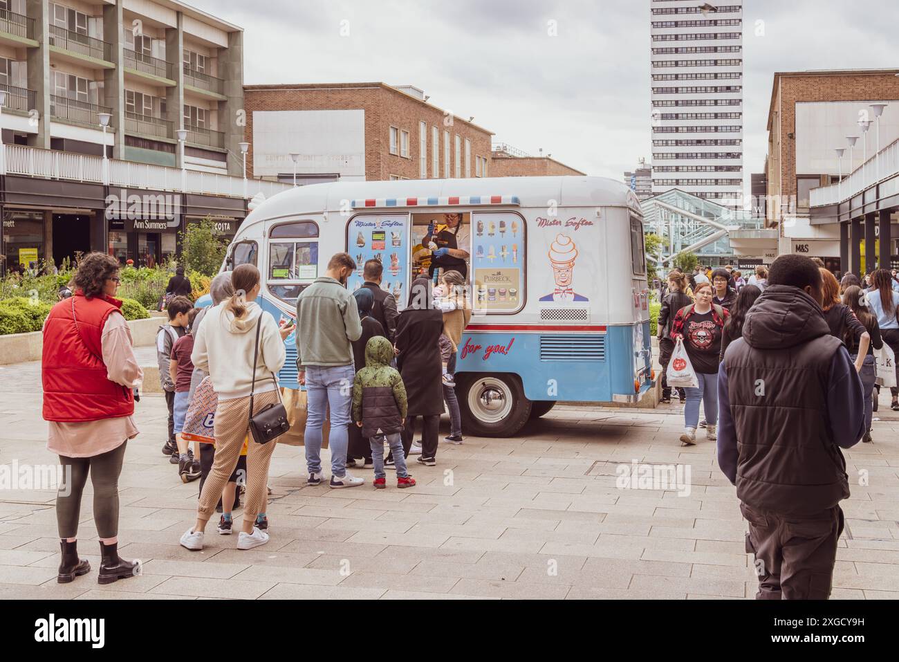 People queue patiently in a line to purchase an ice cream from an ice ...