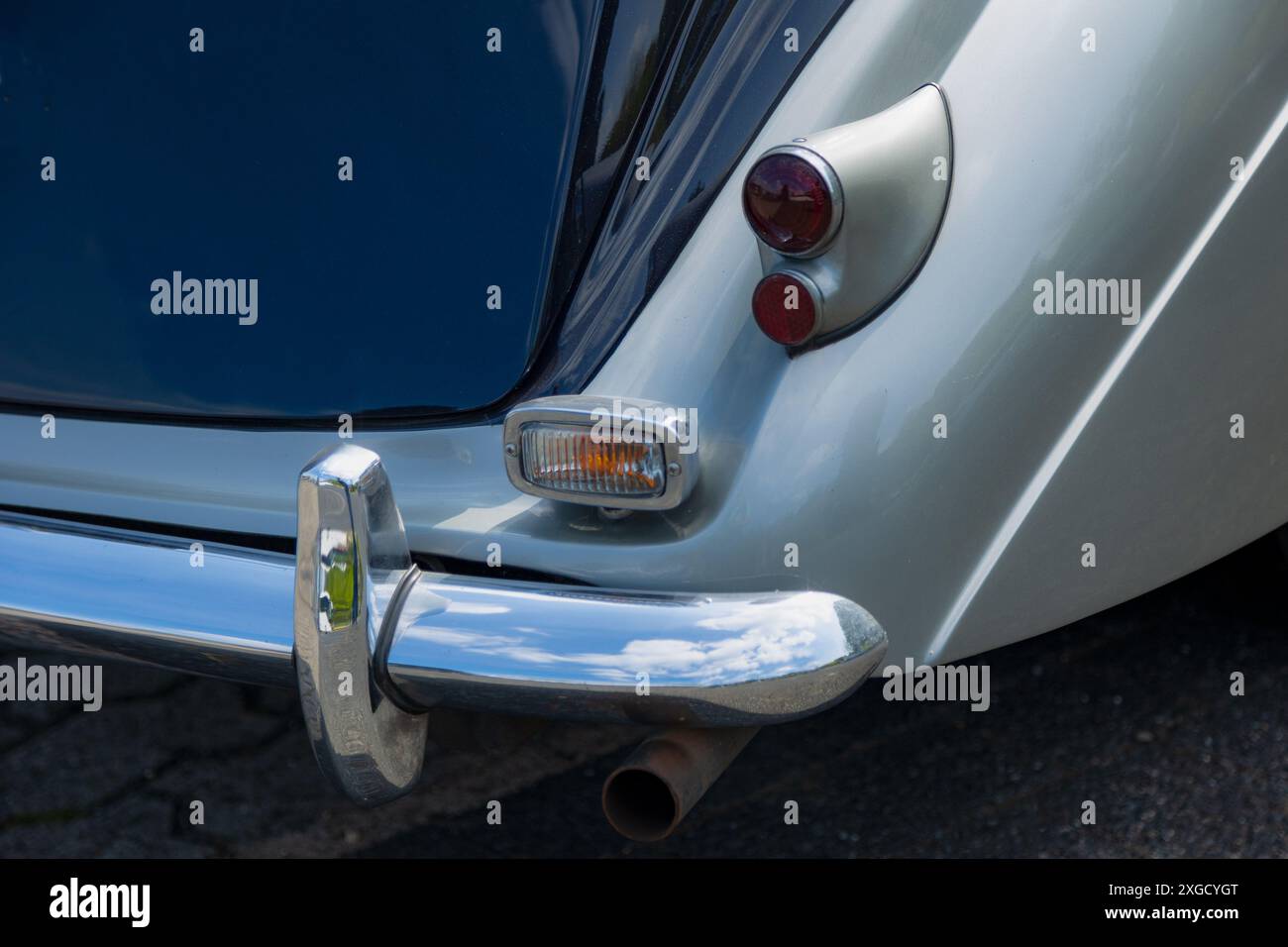 A close-up shot of the rear bumper and taillights of a vintage car. The ...