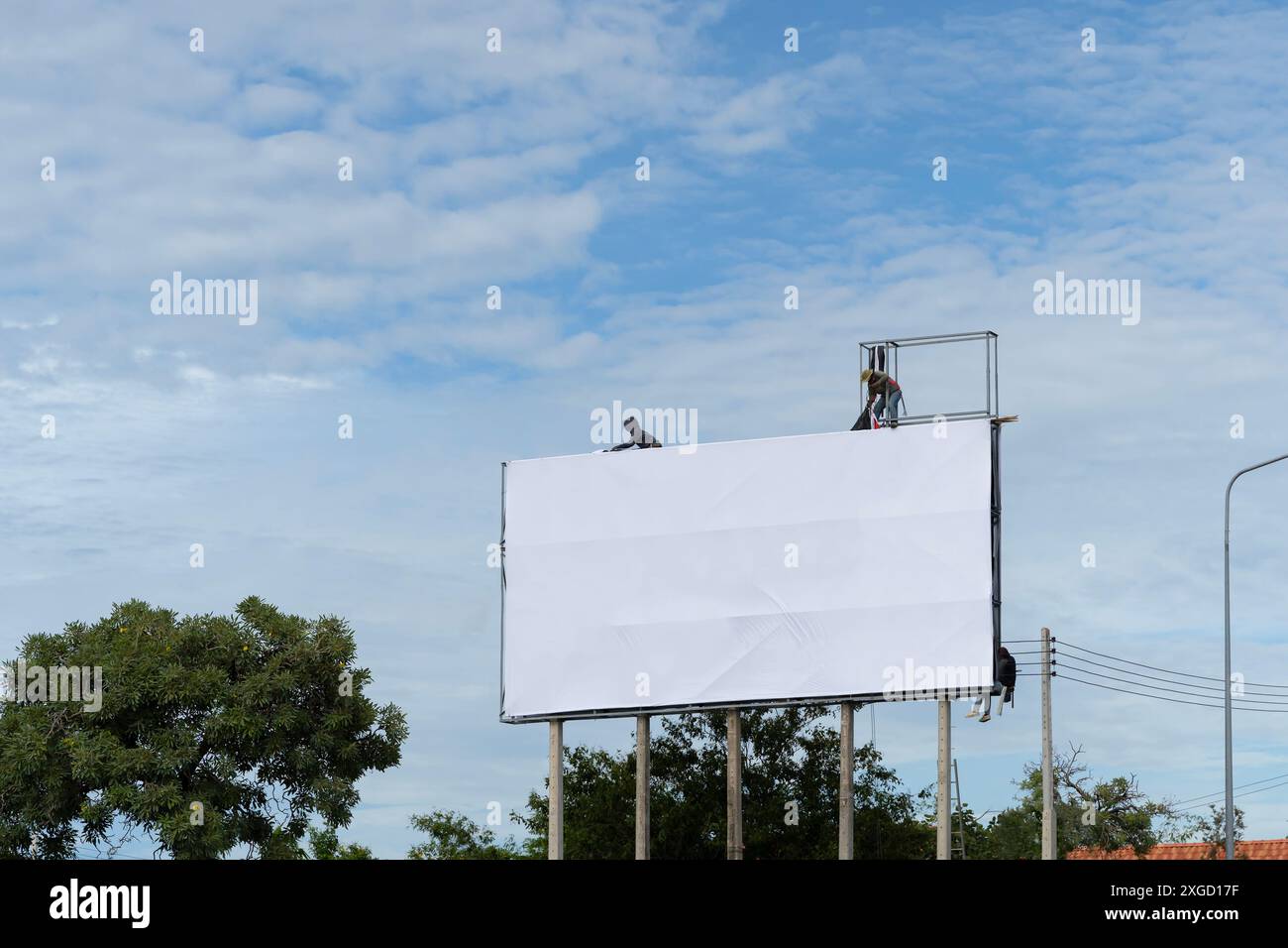 Worker prepares billboard to installing new advertisement. Industrial ...