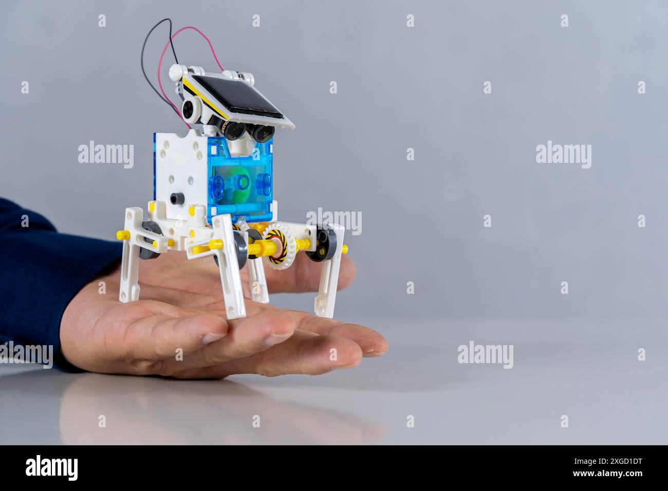 A plastic robot is in the hand of a student placed on the table ...