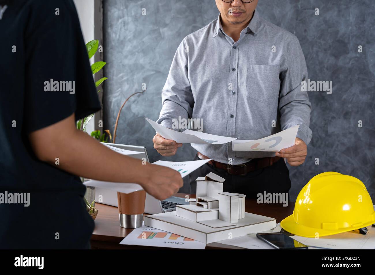 Engineers consulting team close up to design building blueprints paper ...