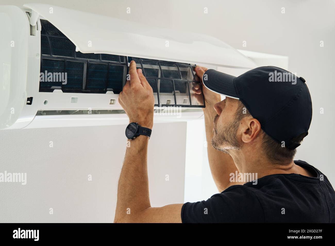 Air conditioner maintenance. Male technician repairs home climate ...