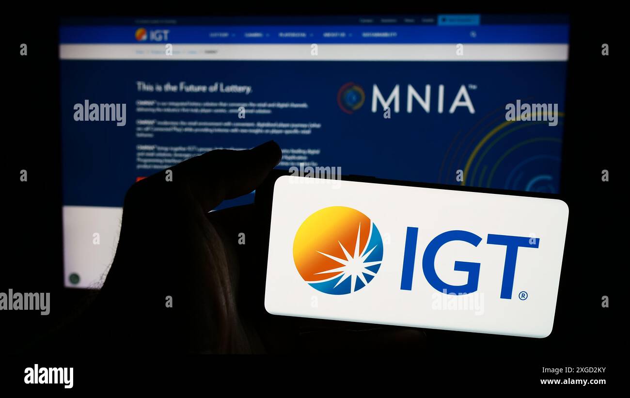 Person holding mobile phone with logo of company International Game ...