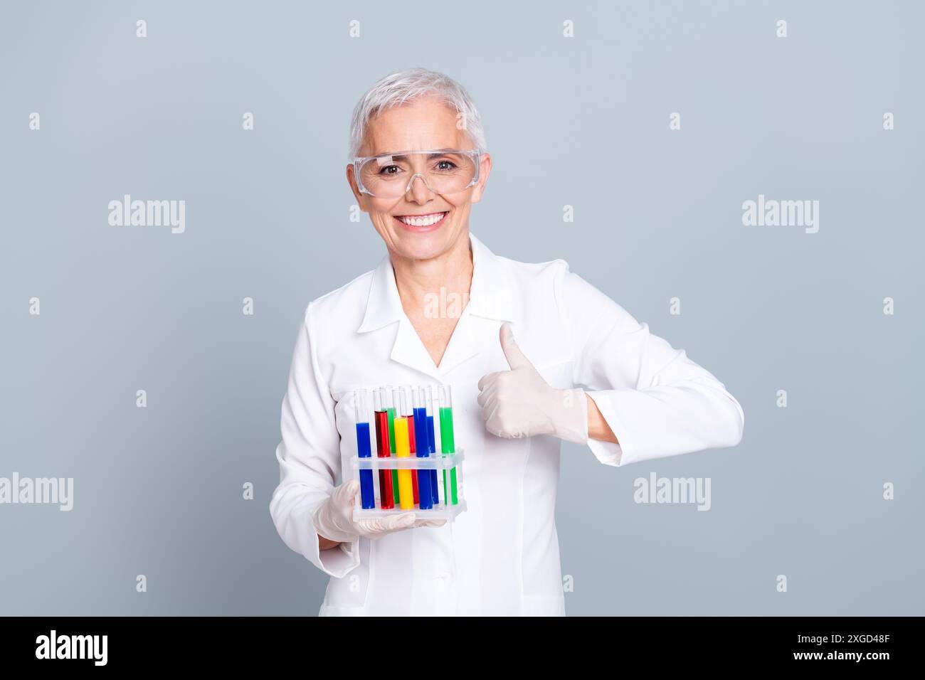 Photo of smiling old lady chemist hold flask with chemical show thumb ...