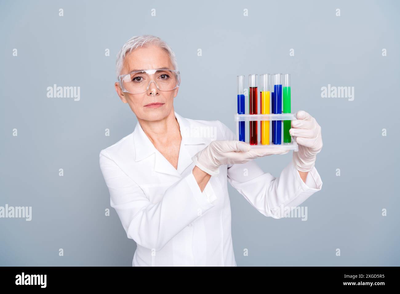 Photo of old woman scientist hold test tube showing isolated grey color ...
