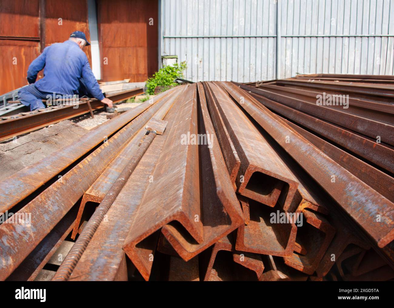 rusty steel profiles stored outdoors, worker steel production Stock ...