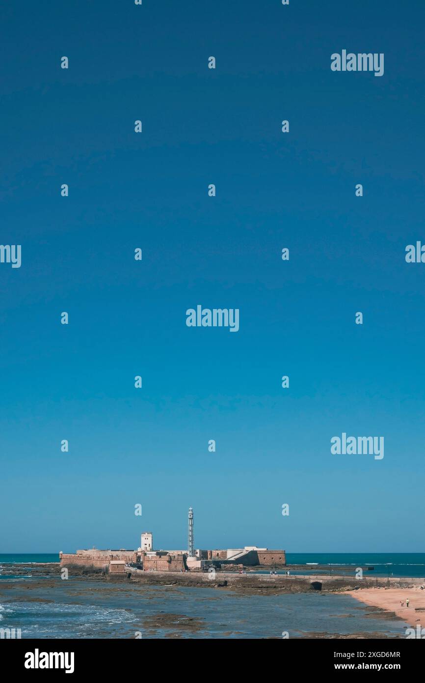 View of the San Sebastian castle, on La Caleta beach, Cadiz, with a huge blue sky serving as ...