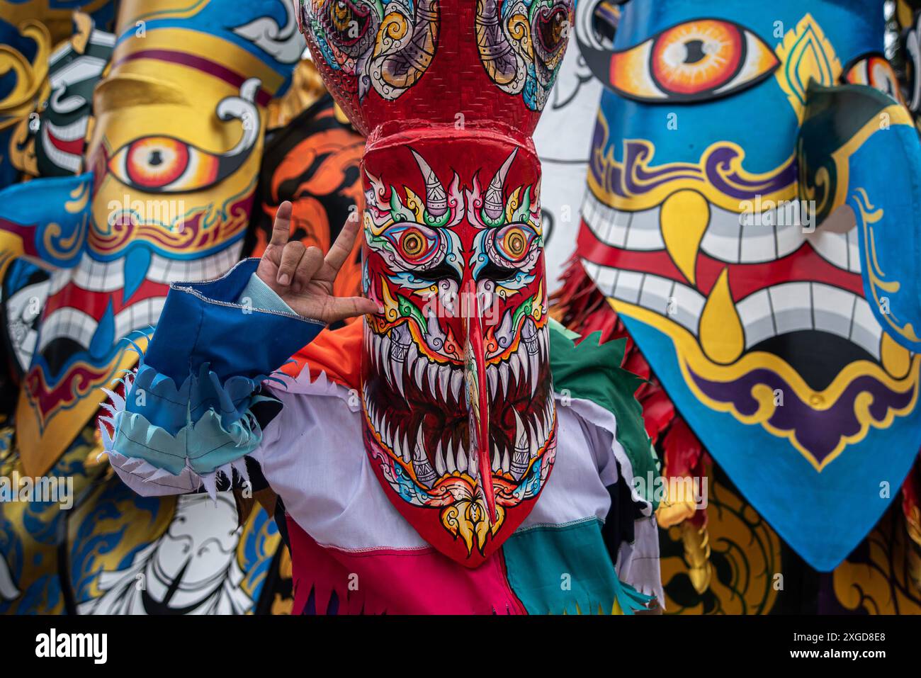 A participant wearing a ghost mask and dressed in costume poses for a ...
