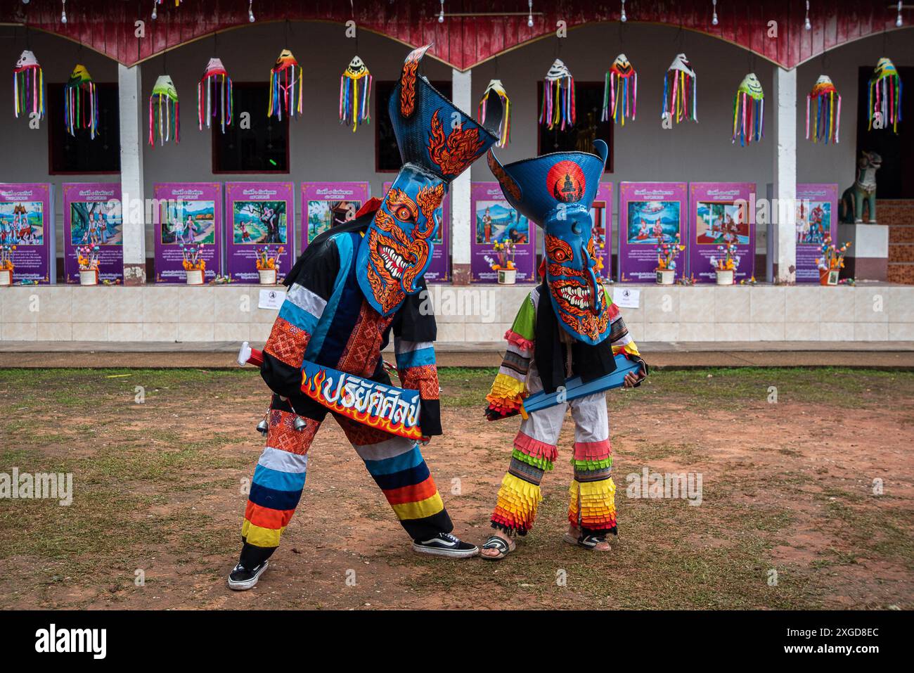 Participants wearing ghost masks and dressed in costumes take part ...