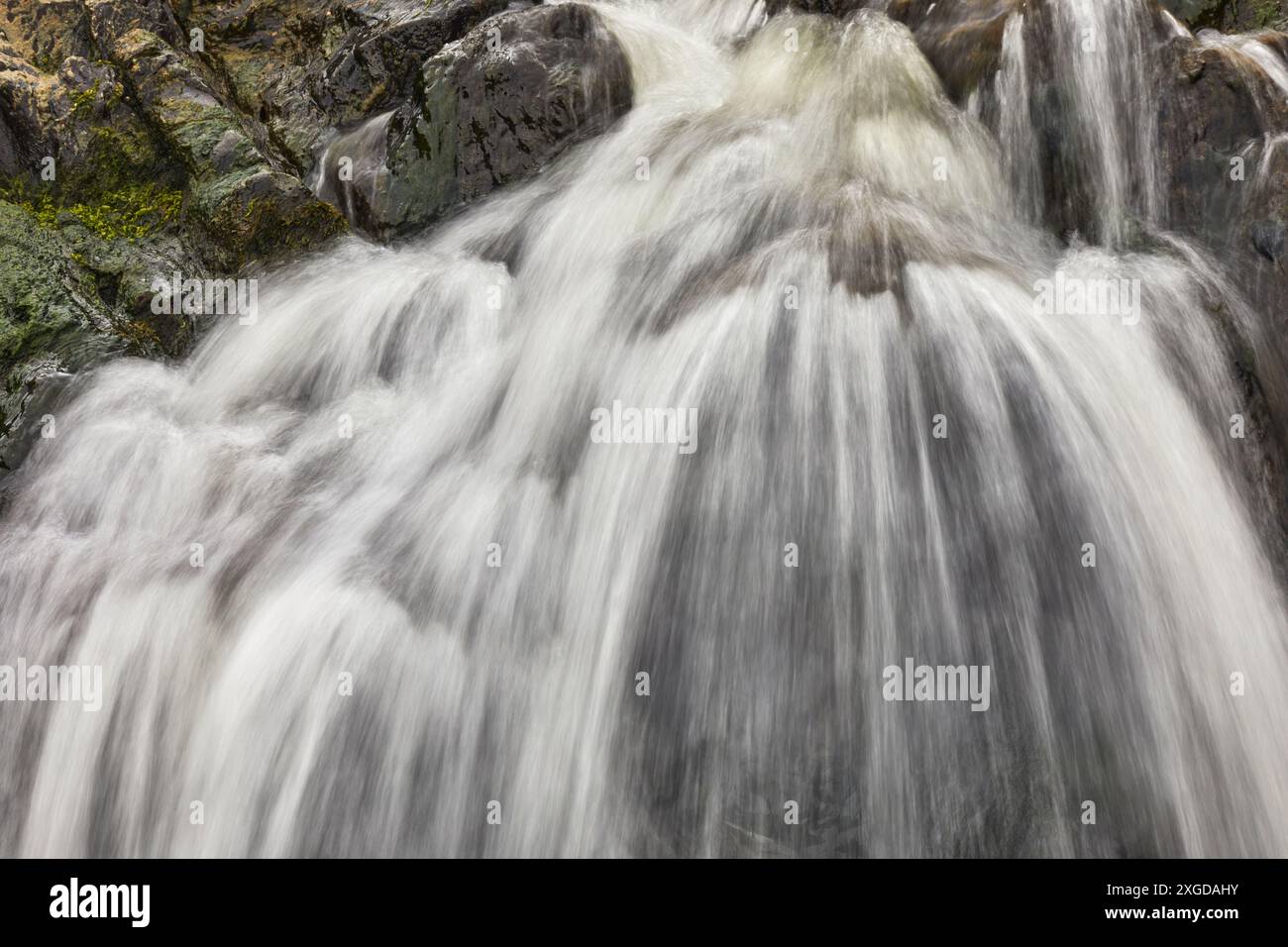 Waterfall pouring down a rocky cliff, with blurred motion, resulting ...