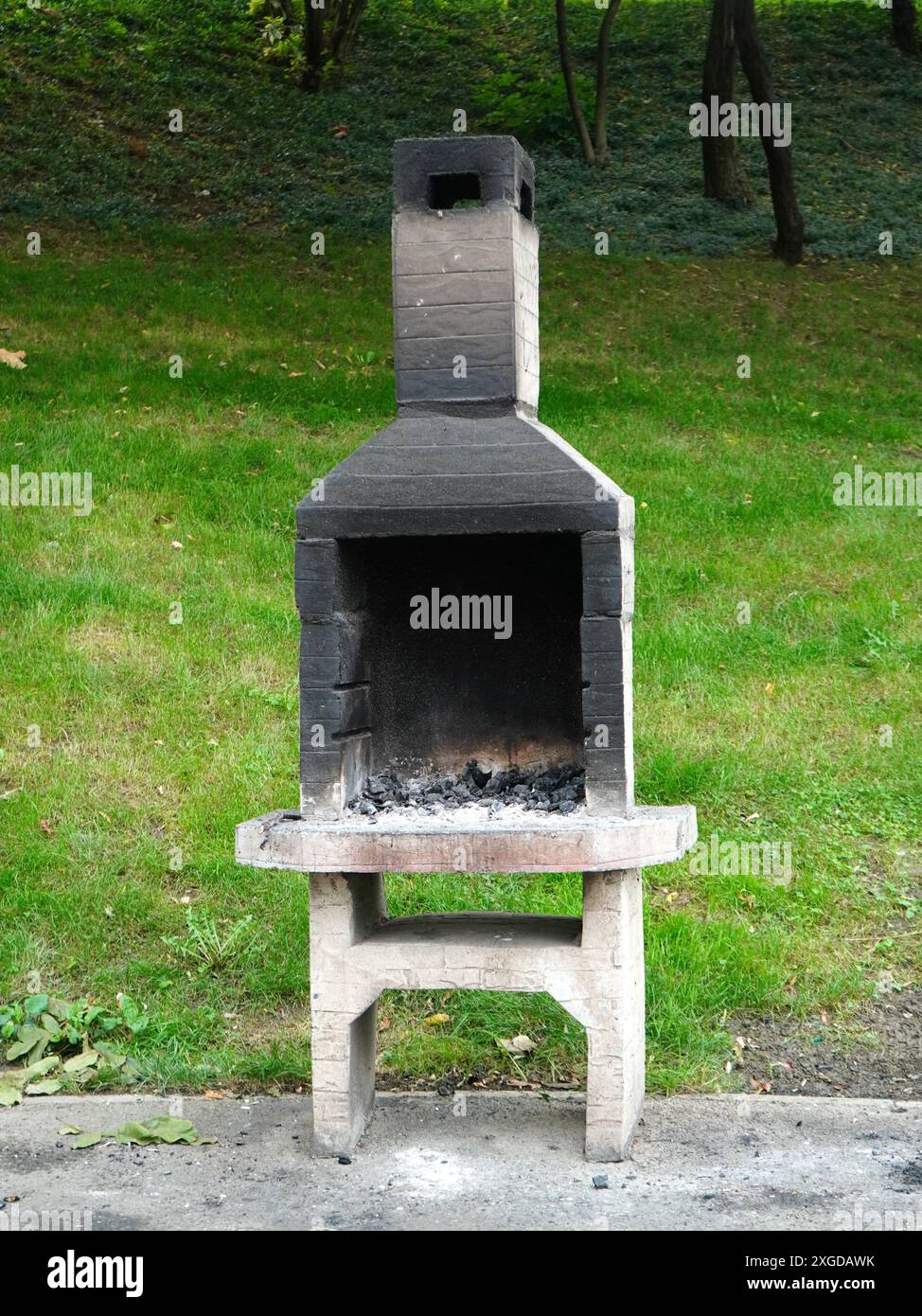 Outdoor concrete barbeque with cold burnt charcoal pieces Stock Photo ...