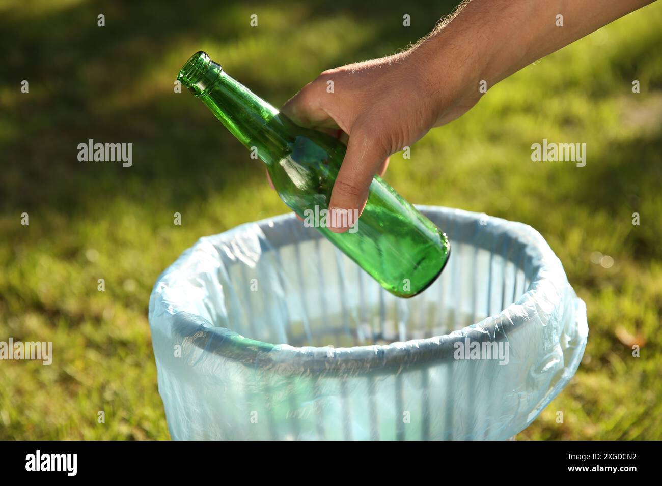 Man throwing glass bottle into garbage bin outdoors, closeup Stock ...
