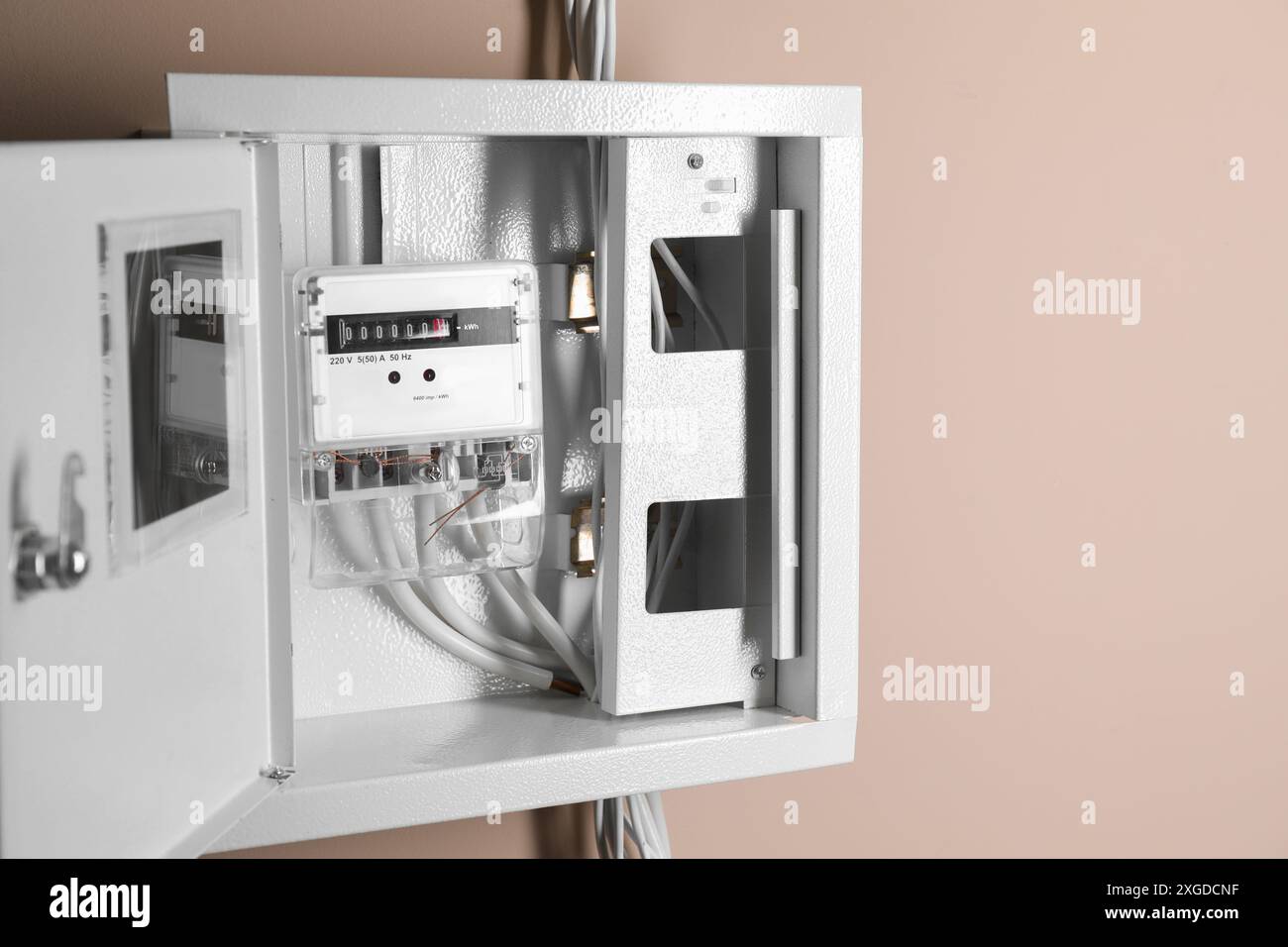 Electric meter in fuse box on beige wall. Energy measuring device Stock ...