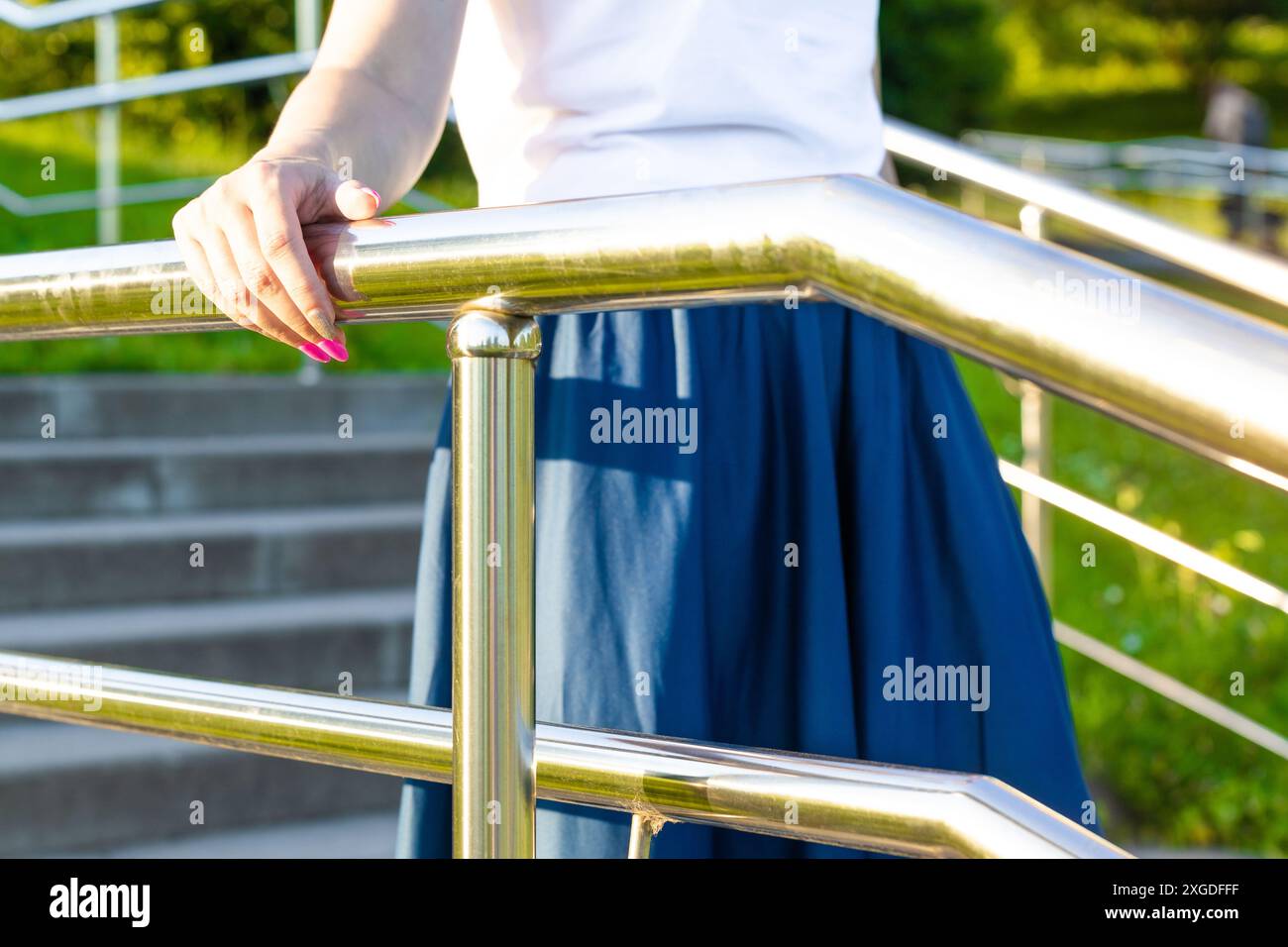 woman's hand holding onto the metal staircase railing. a man goes down ...