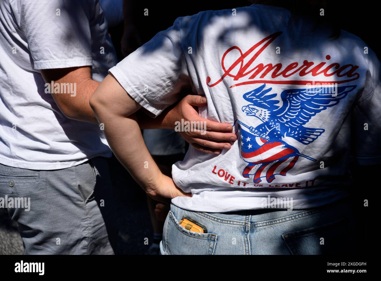 A couple wearing matching "American Love It or Leave It" T-shirts watch ...