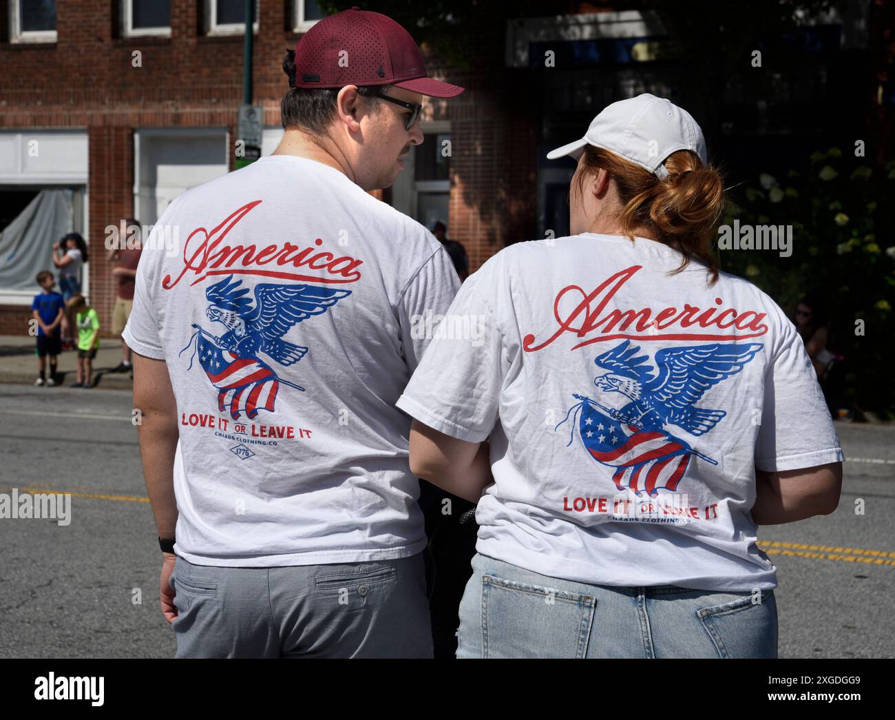 A couple wearing matching "American Love It or Leave It" T-shirts watch ...