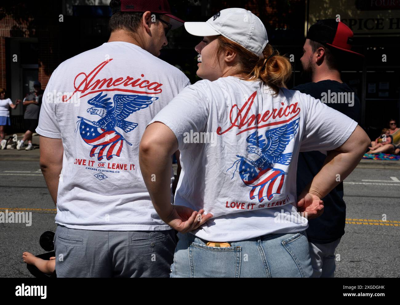 A couple wearing matching "American Love It or Leave It" T-shirts watch ...