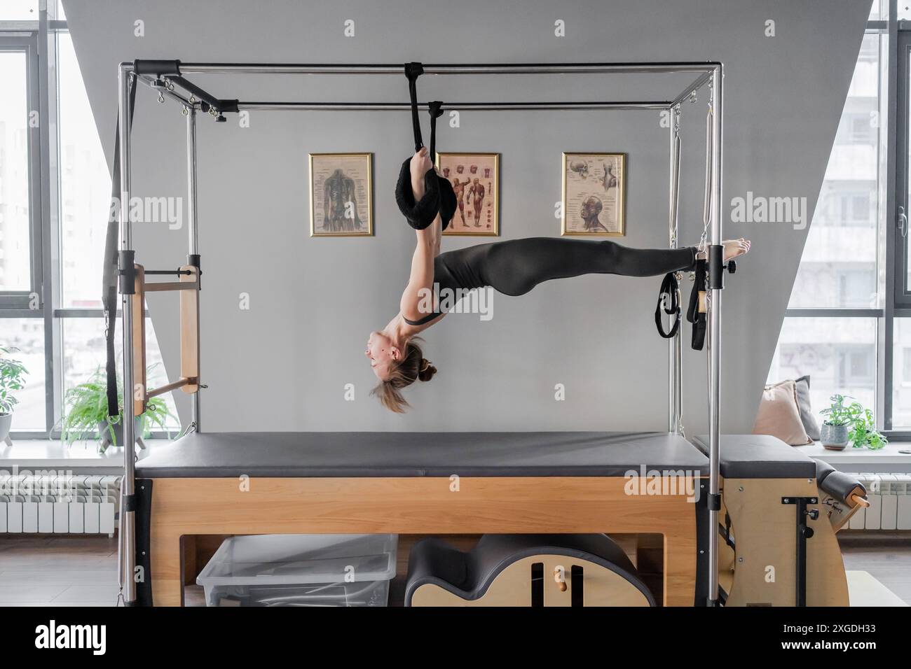 Pilates fitness trainer doing back strengthening exercises on in ...