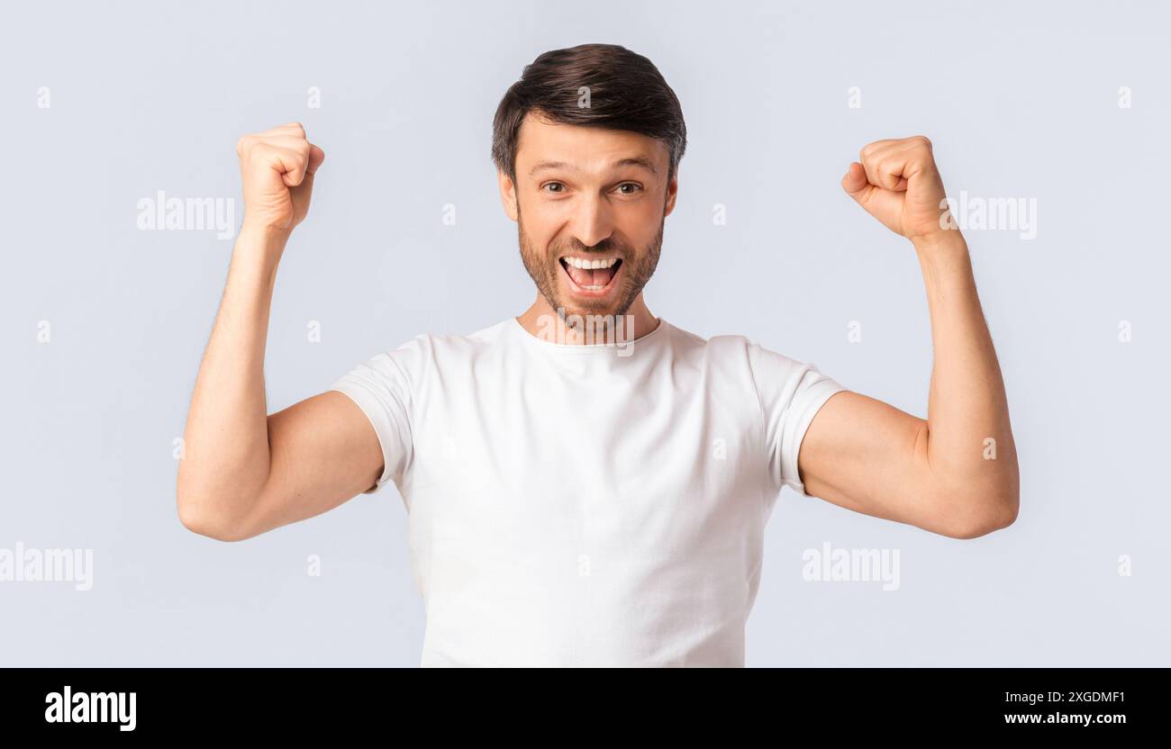 Joyful Man Shaking Fists Rejoicing Victory On White Studio Background ...