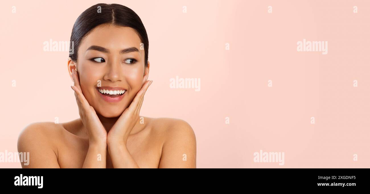 Smiling Asian Woman Holding Cheeks Against Pink Background Stock Photo ...