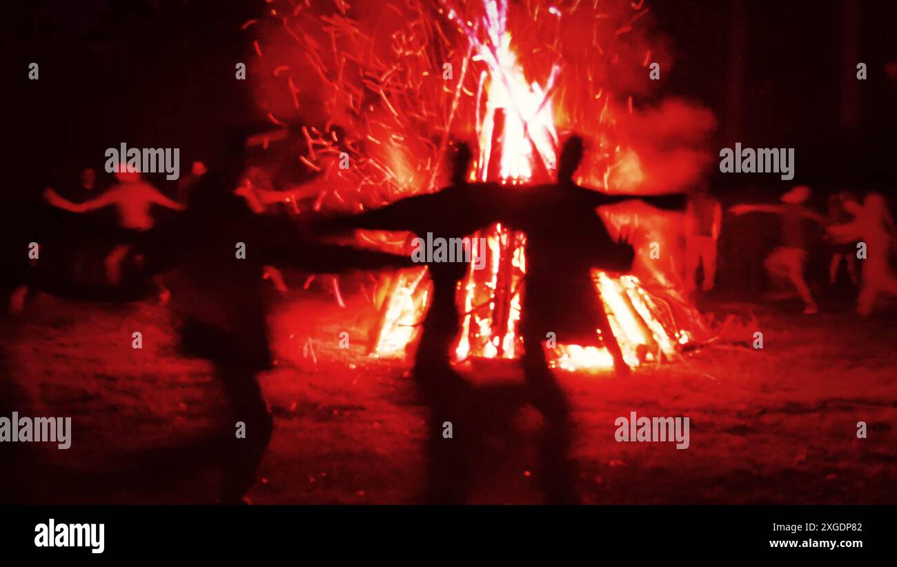 Huge fire at night and young people around. Pagan festival of Walpurgis ...