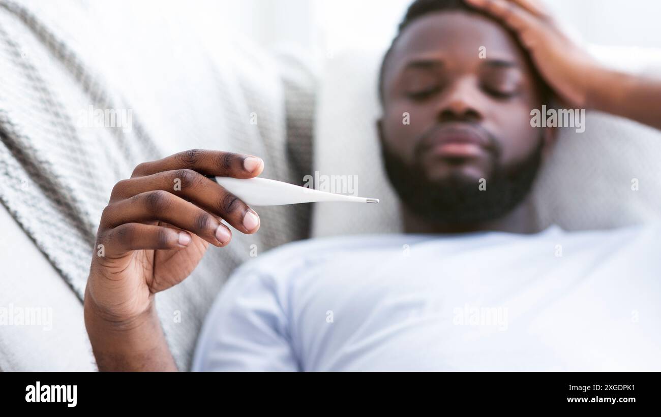 Man Checking Temperature With Thermometer While Lying In Bed Stock ...