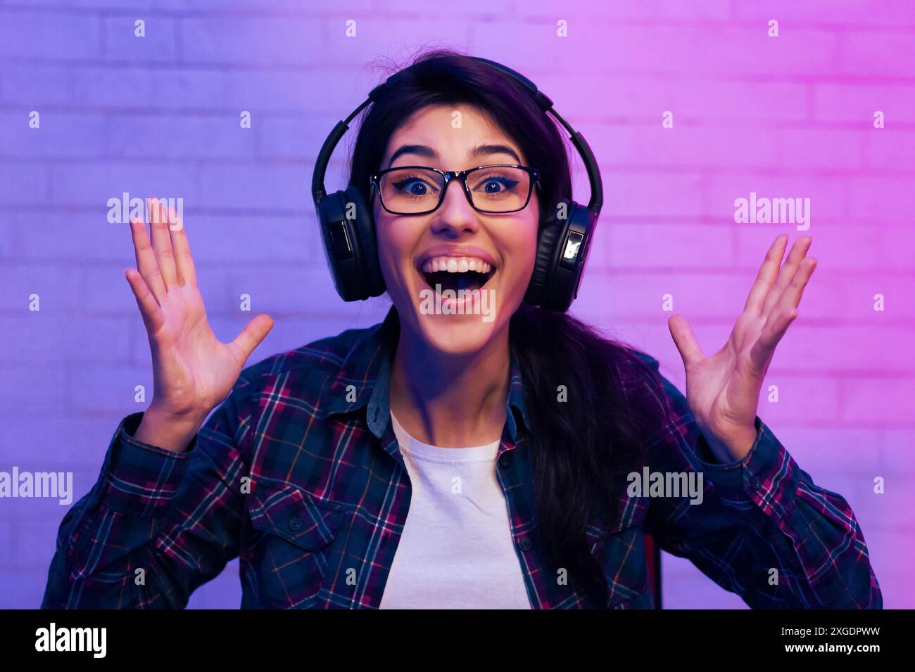 Excited Gamer Wearing Headphones and Glasses in Purple Lit Room Stock ...
