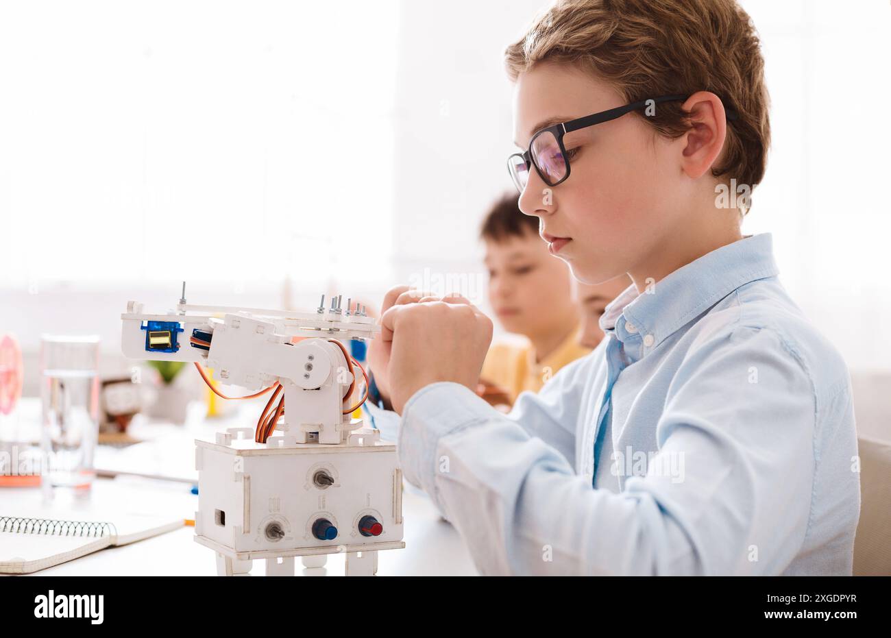 Young Boy Building Robot Arm in Classroom Setting Stock Photo - Alamy