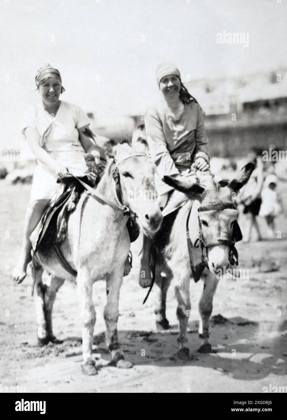 Two women riding donkeys at the seaside during the 1930s Stock Photo ...