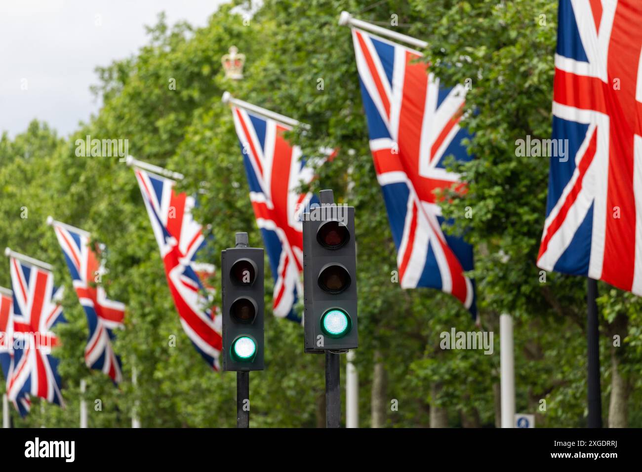 Green traffic light with British union jack flags and foliage ...