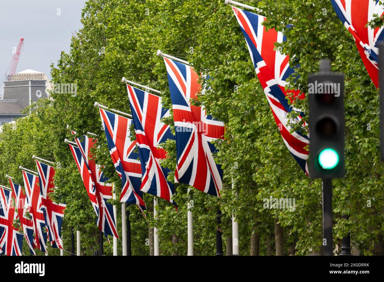 Green traffic light with British union jack flags and foliage ...