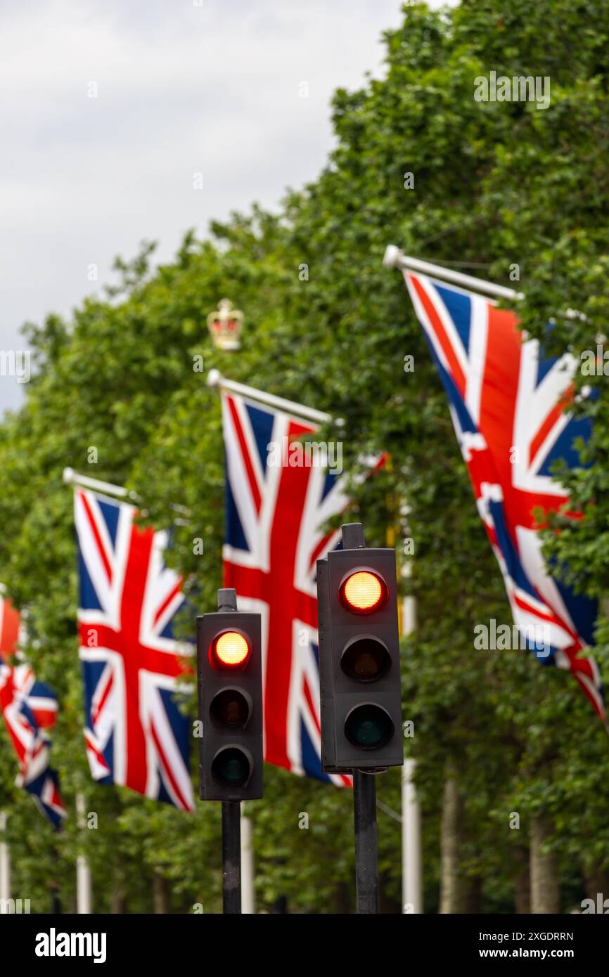 Red traffic light with British union jack flags and foliage background ...