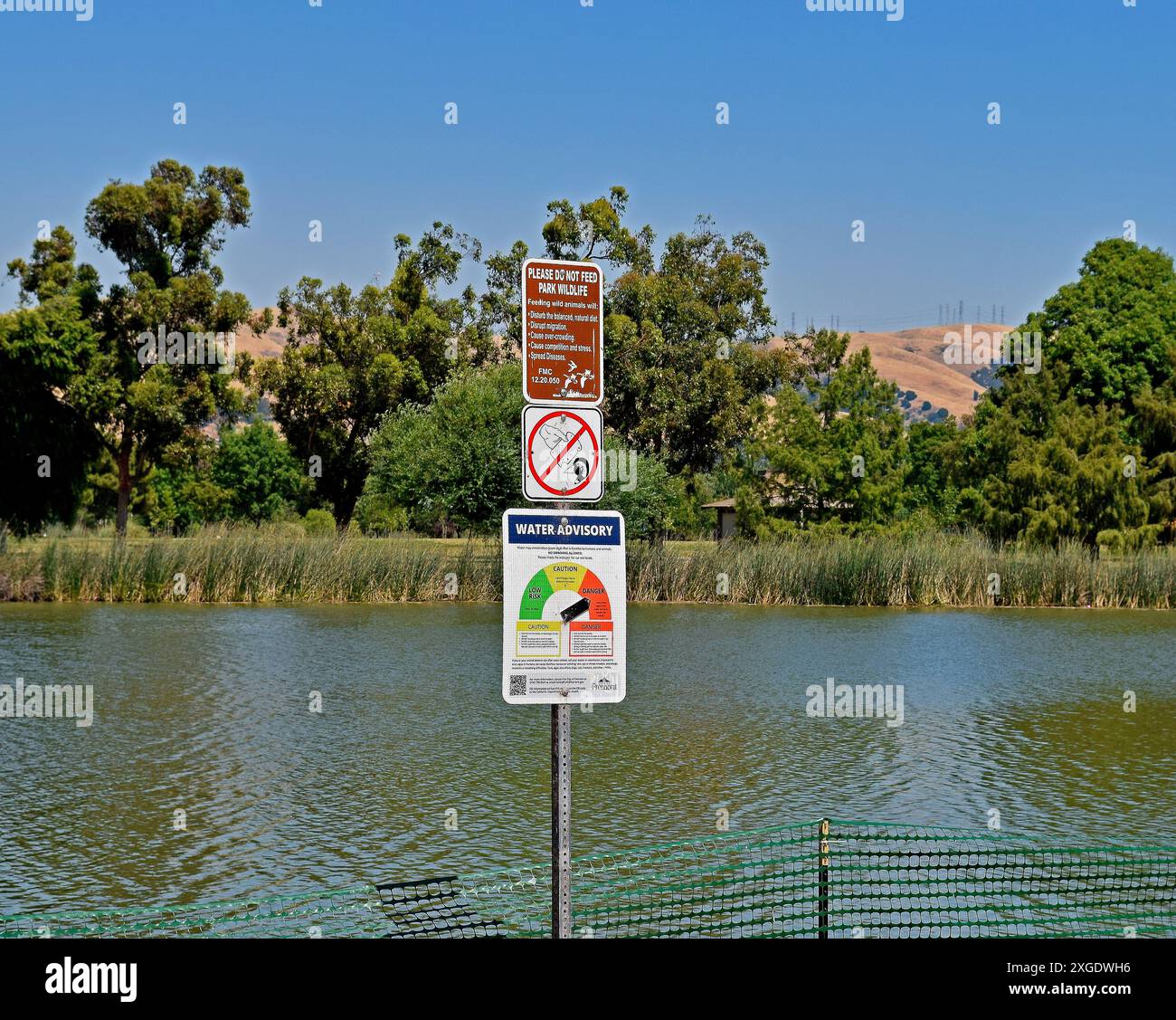 do not feed wildlife sign and water advisory sign set at danger for man ...