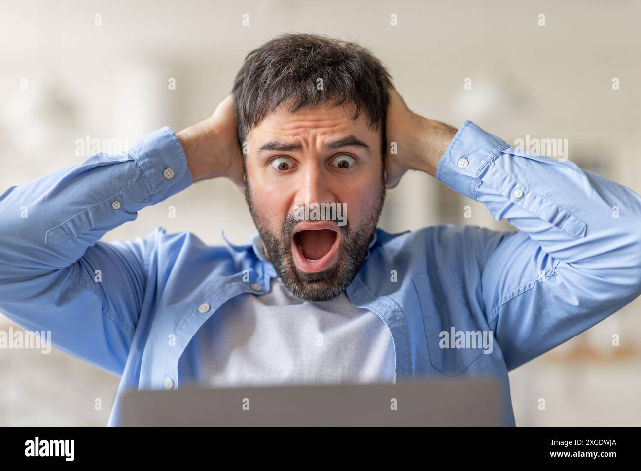 Shocked Man Reacts To Laptop Screen While Sitting At Home Stock Photo ...