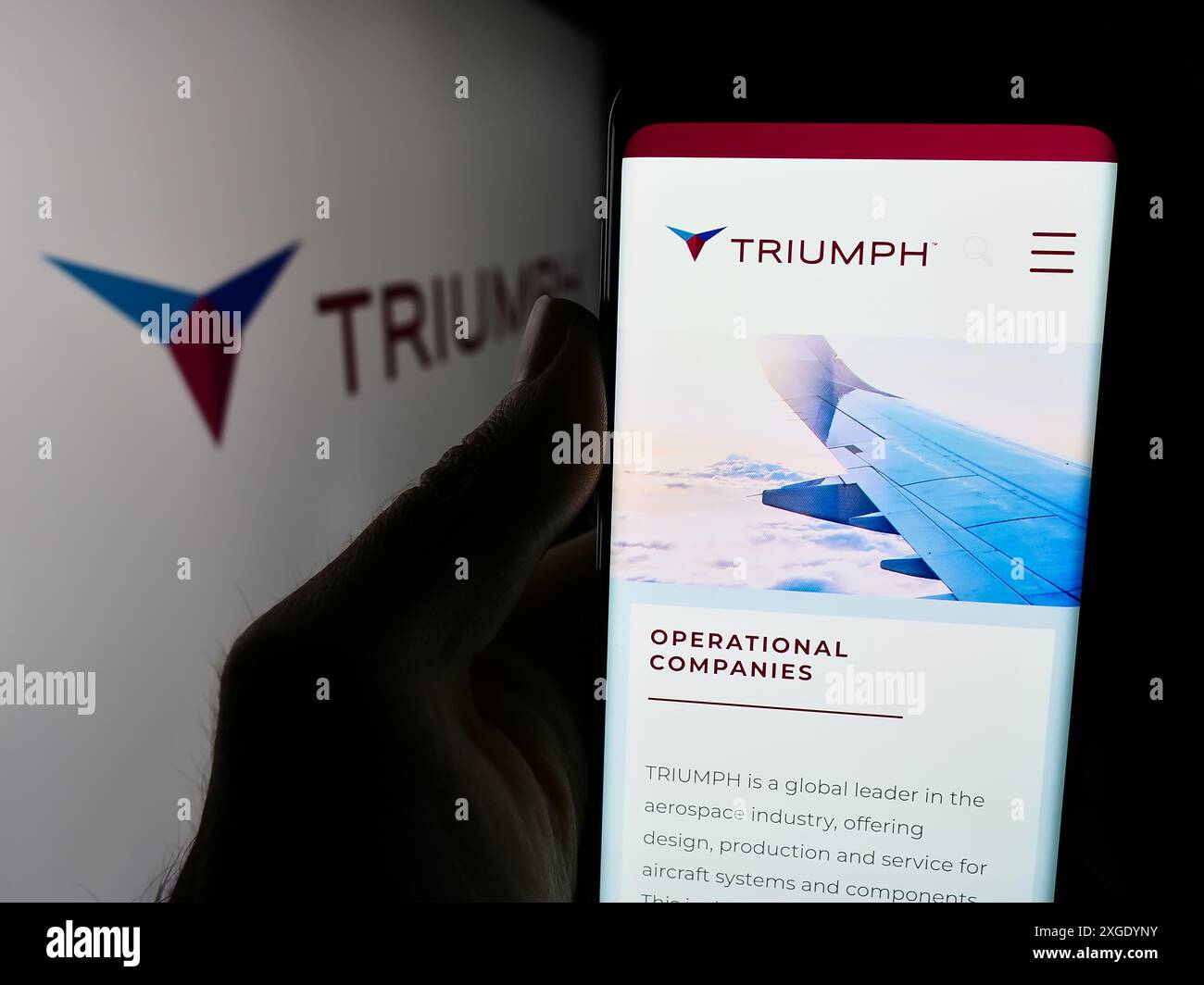 Person holding smartphone with webisite of US aerospace company Triumph ...