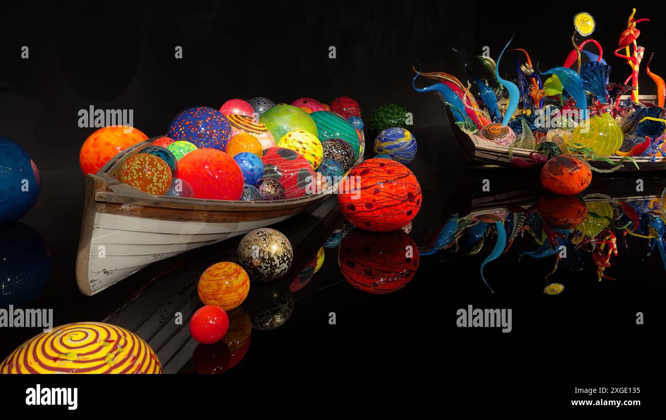 wo boats filled with colorful glass spheres and whimsical objects are ...