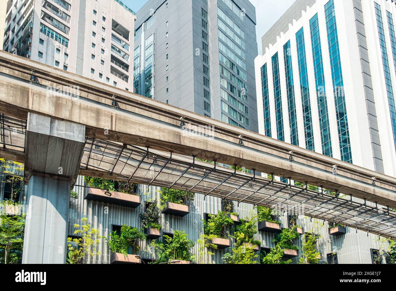 Modern skyscrapers and metro bridge with green plants on urban building ...