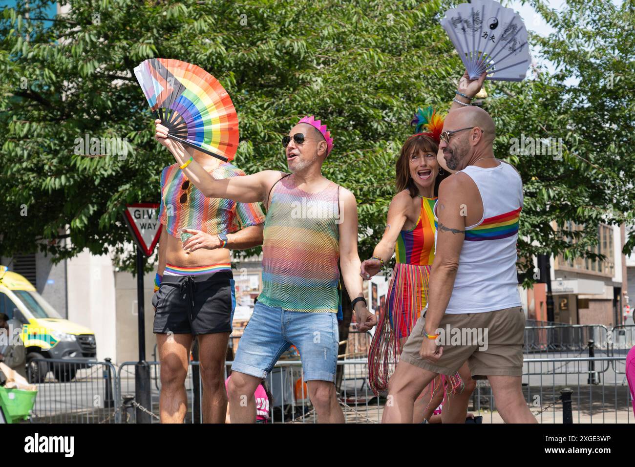 Revellers dancing and partying with rainbow coloured fans at the London ...