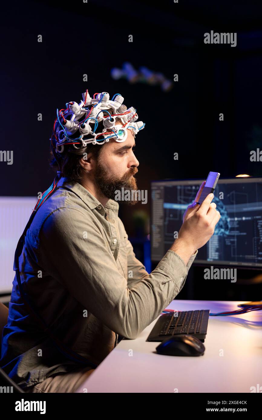 Engineer with EEG headset inserting cartridge into PC to use high tech ...