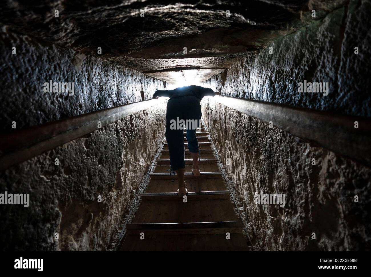 Visitor ply a narrow tunnel to explore one of ancient Egypts many tombs ...