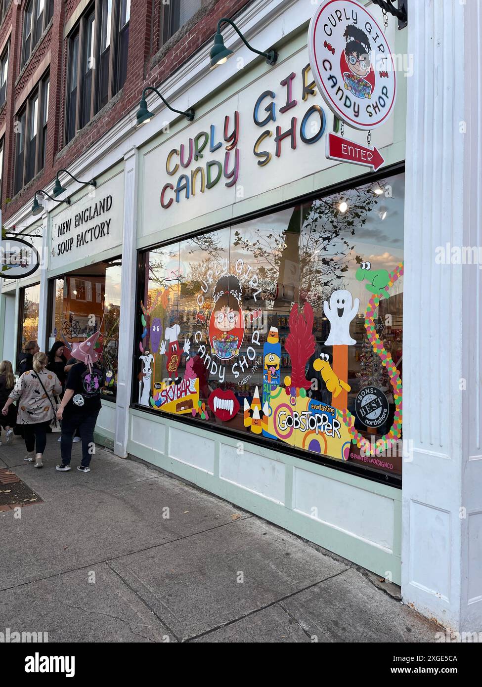 People gather at the entrance of a candy shop where the store's windows ...