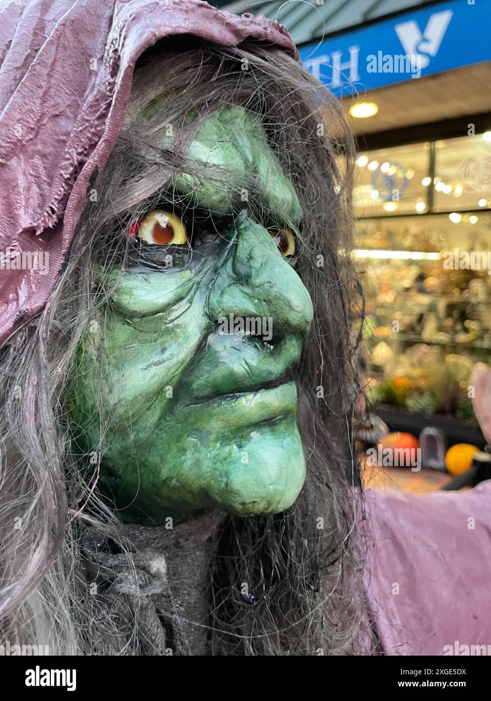 A scary witch and monster stand outside a haunted house attraction in ...